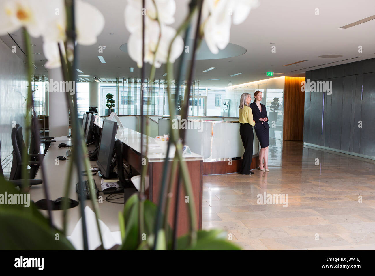 Businesswomen talking in reception area of office Stock Photo - Alamy