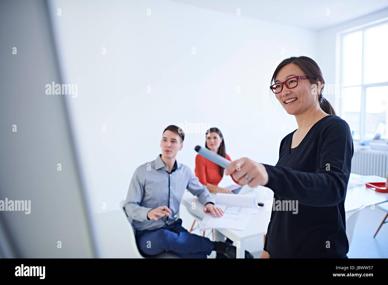 Colleagues in office watching presentation Stock Photo - Alamy