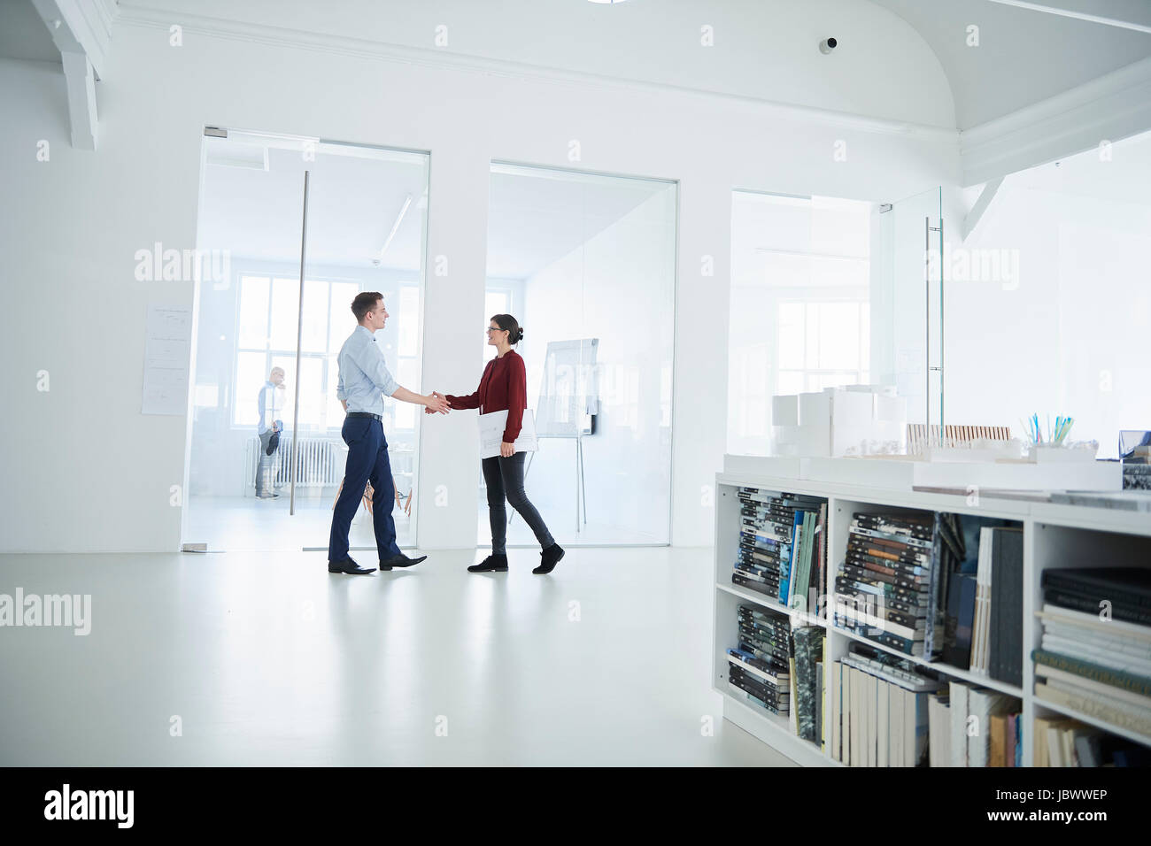 Colleagues in office conference room shaking hands Stock Photo - Alamy