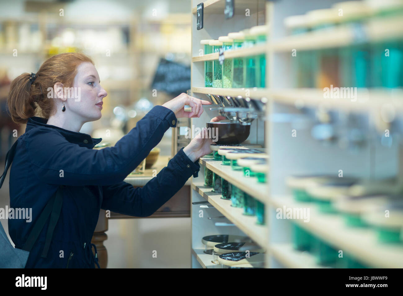Woman using self service dispensers in shop Stock Photo - Alamy