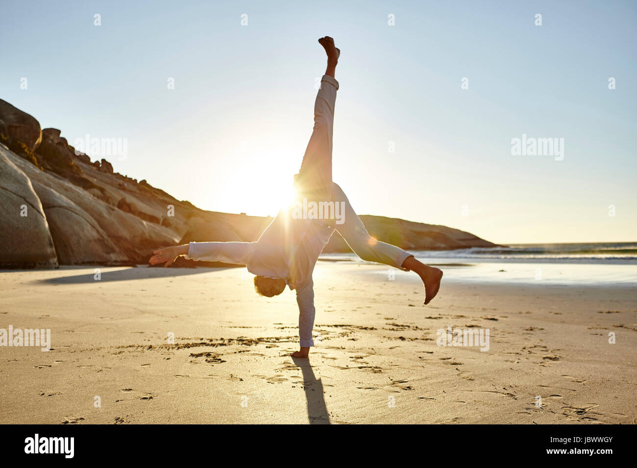 Mature man doing cartwheel on beach, Cape Town, South Africa Stock ...