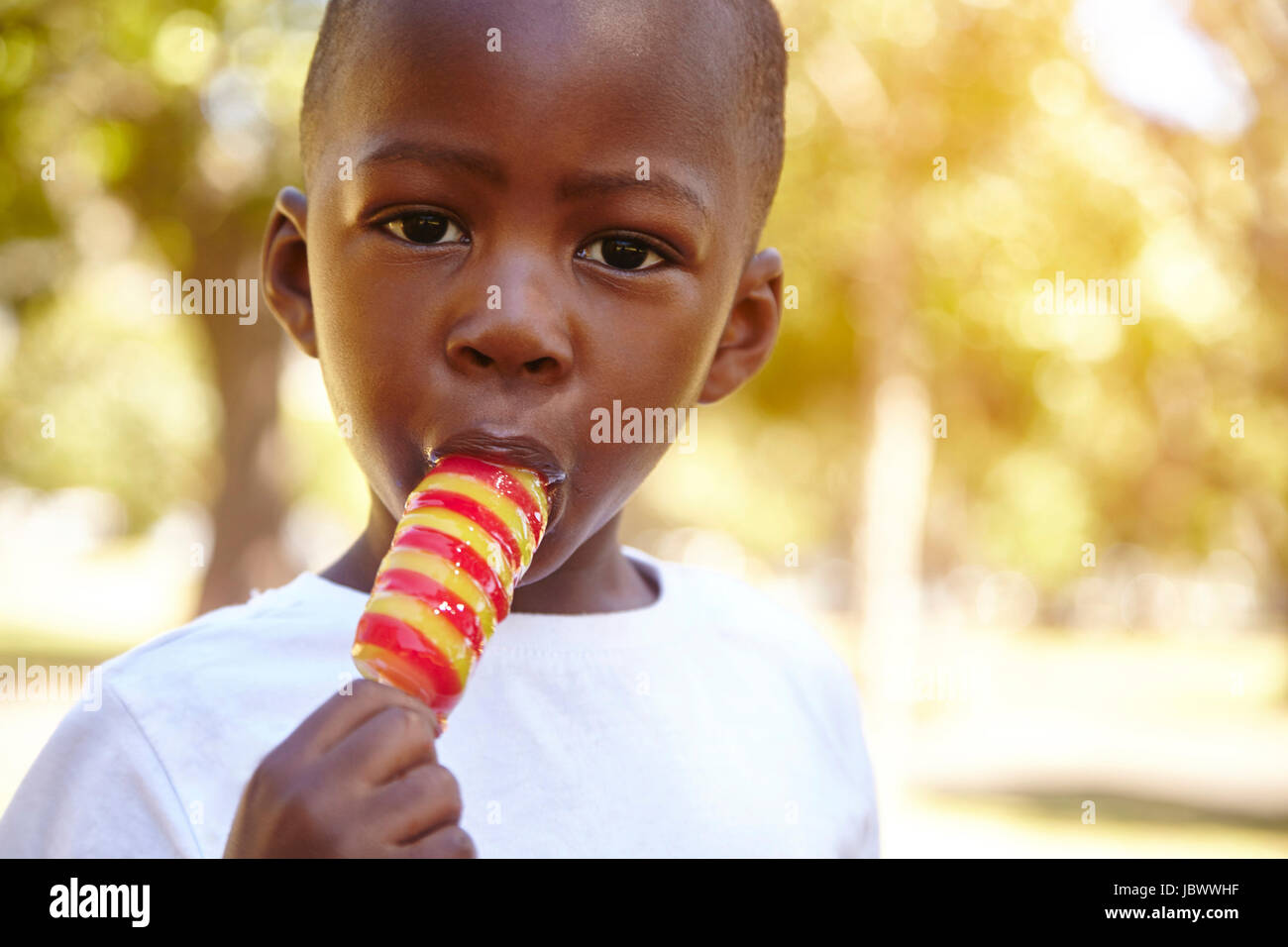 Boy eating ice lolly Stock Photo - Alamy
