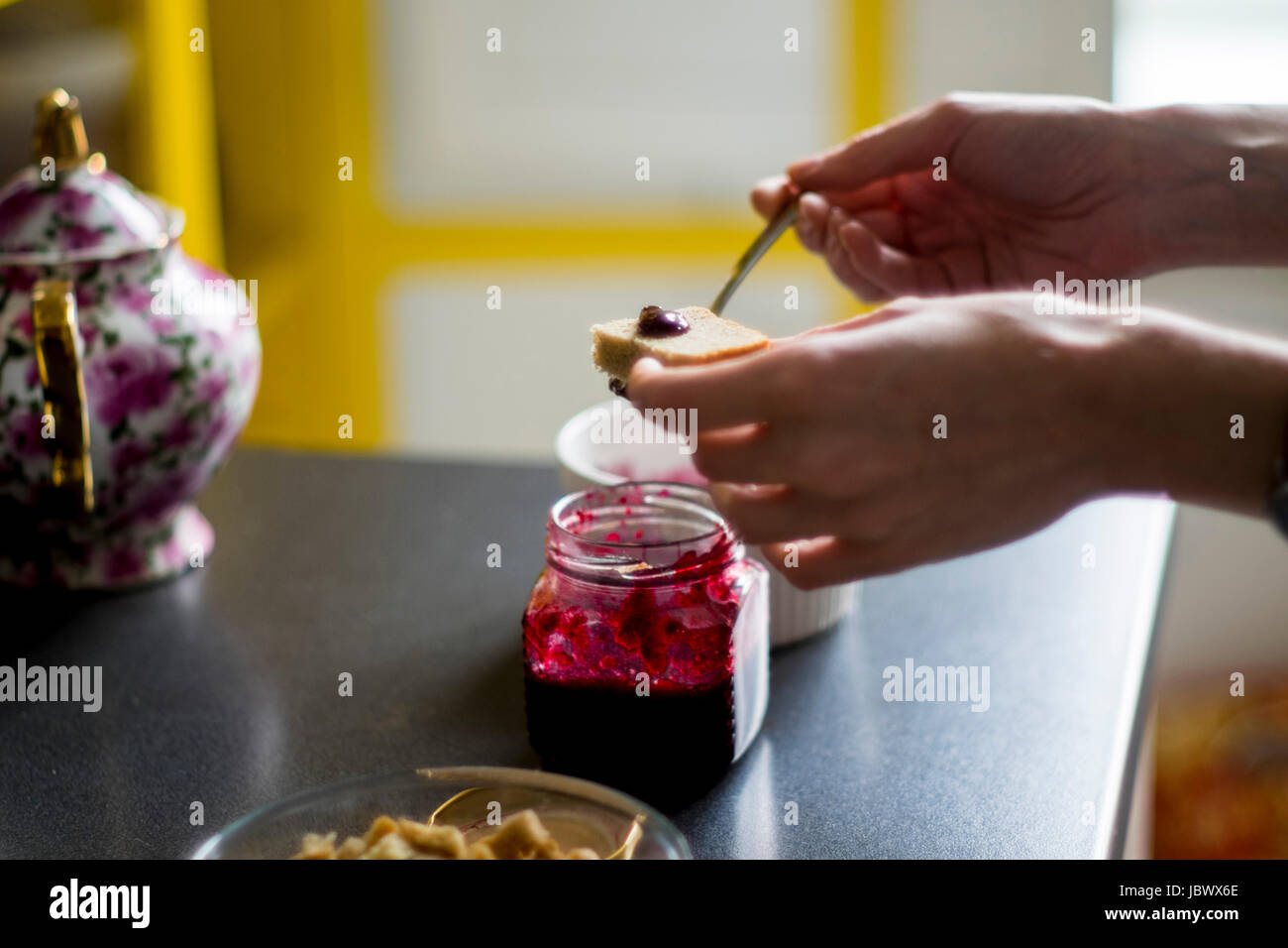 Woman spooning jam onto bread, close-up Stock Photo - Alamy