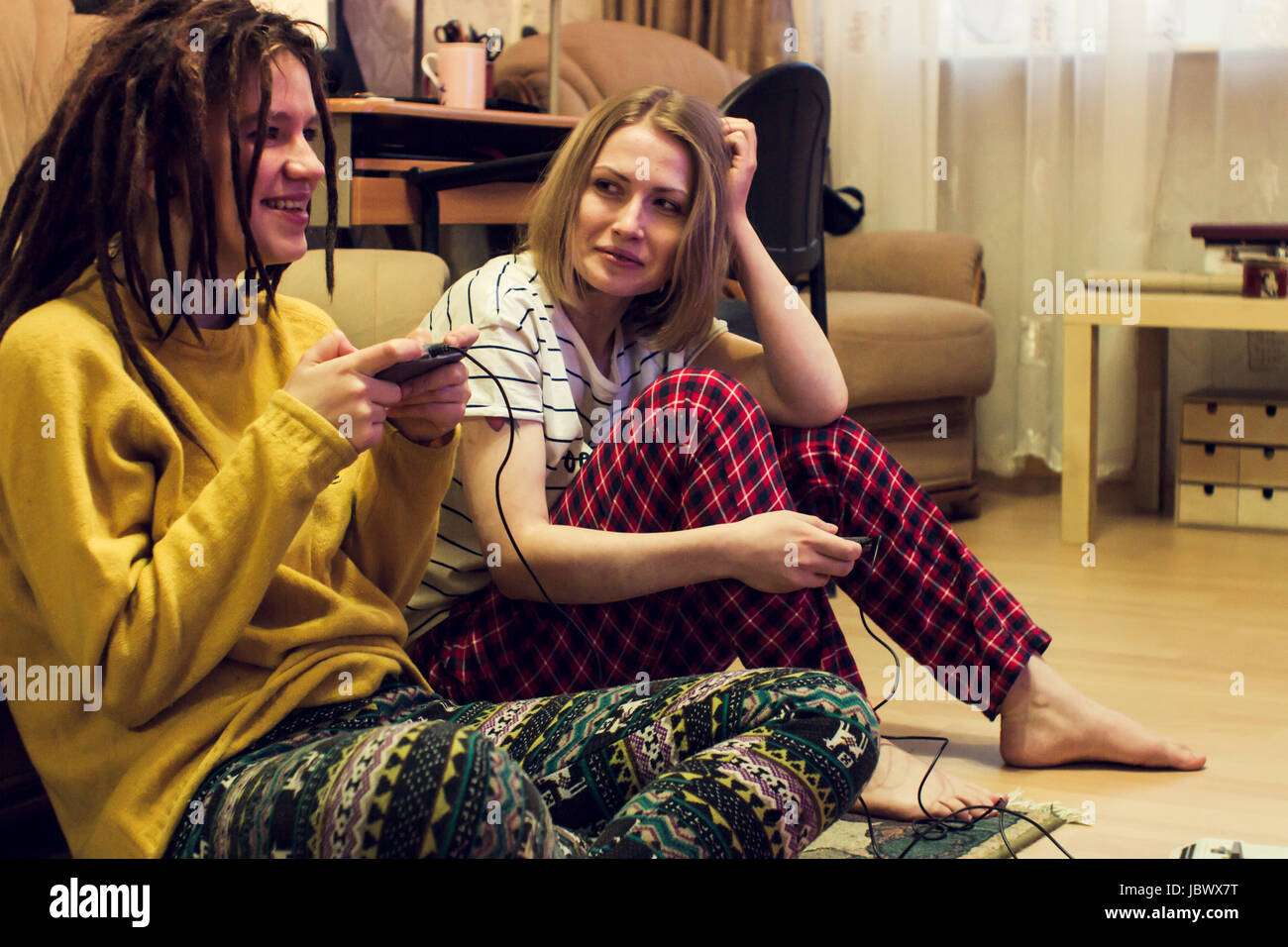 Two friends, sitting at home, playing computer game Stock Photo - Alamy