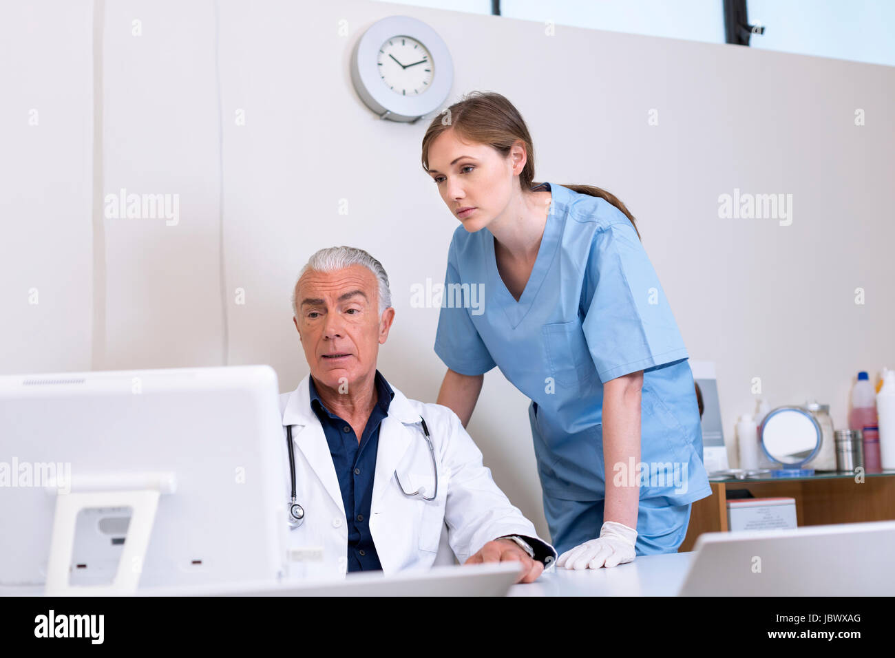 Doctors looking at computer Stock Photo - Alamy