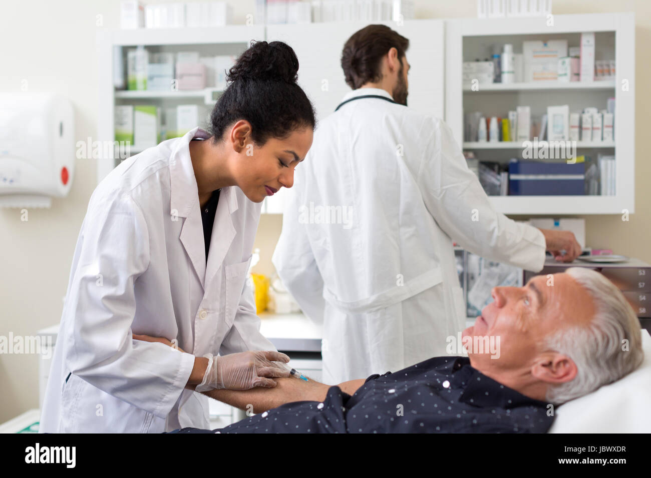 Doctor extracting patient's blood with syringe Stock Photo - Alamy