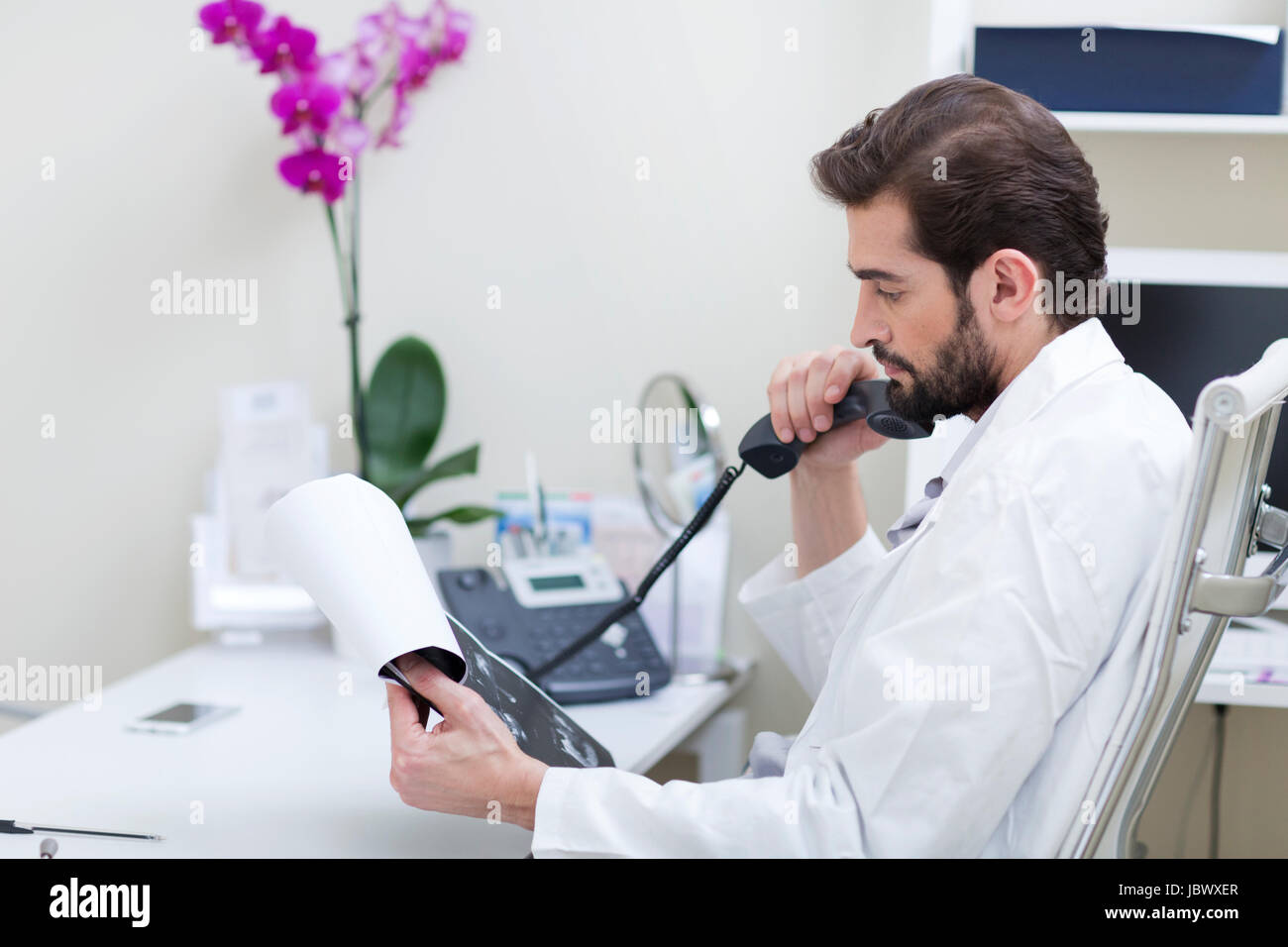 Doctor at desk making telephone call Stock Photo - Alamy