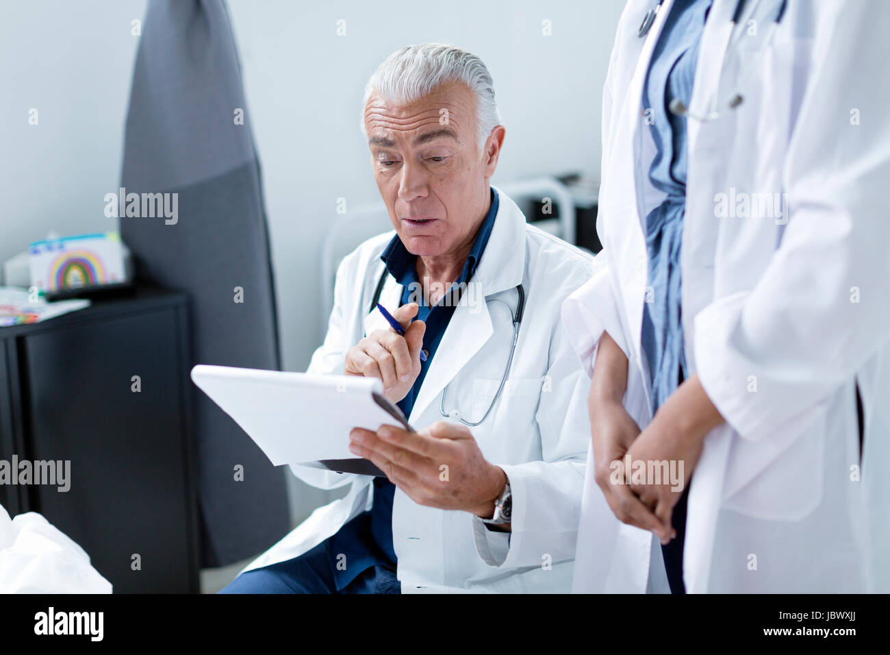 Doctor looking at medical chart Stock Photo - Alamy