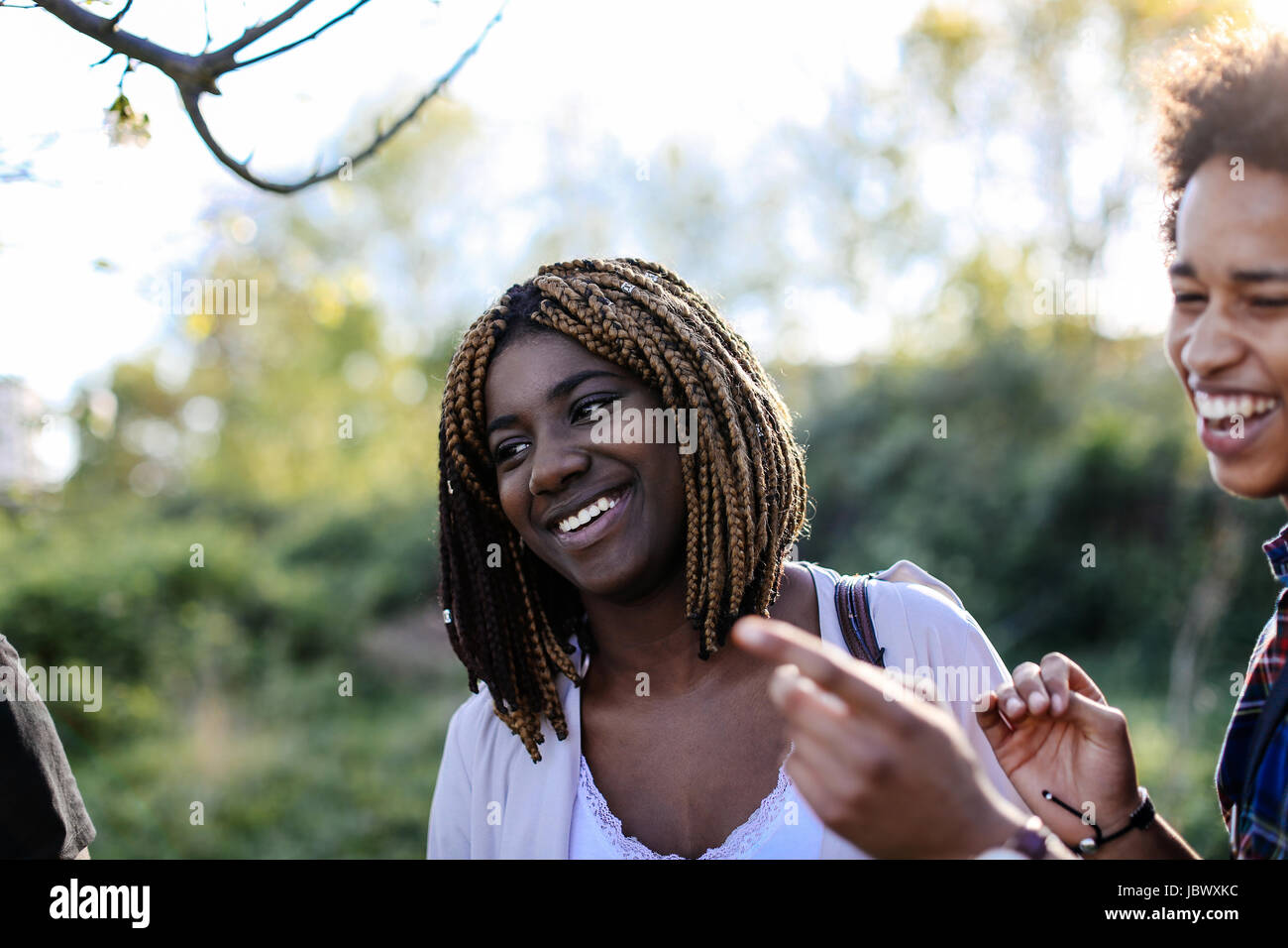 Two friends, walking through park, laughing Stock Photo - Alamy