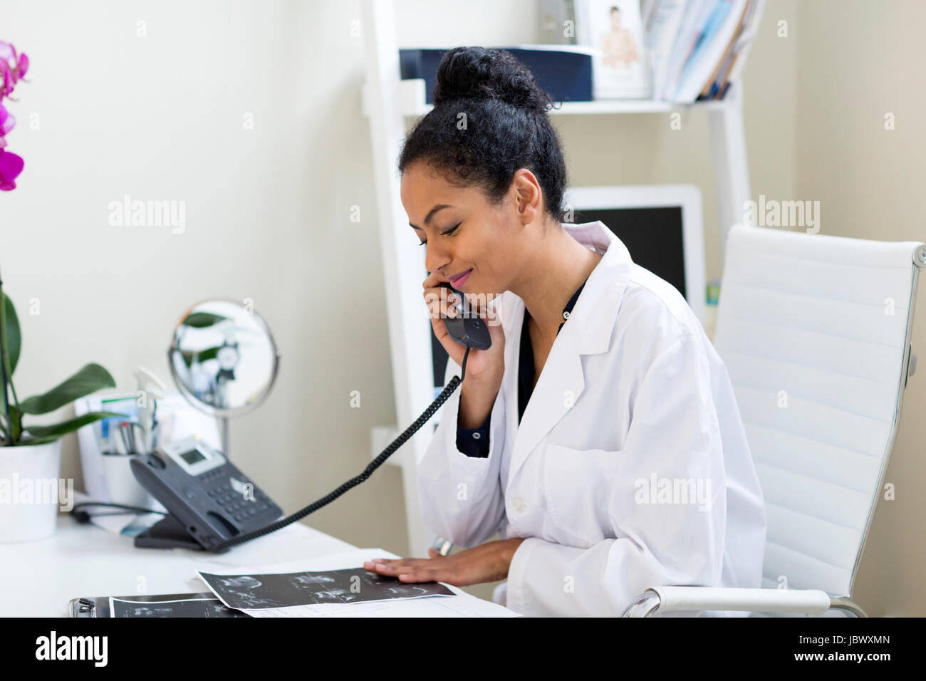 Doctor at desk making telephone call Stock Photo - Alamy