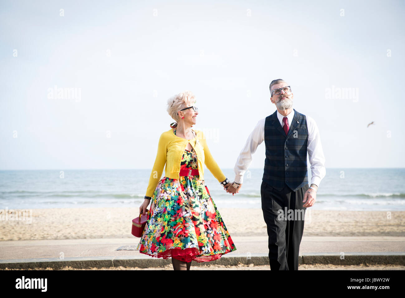 1950's vintage style couple holding hands and strolling on beach Stock ...