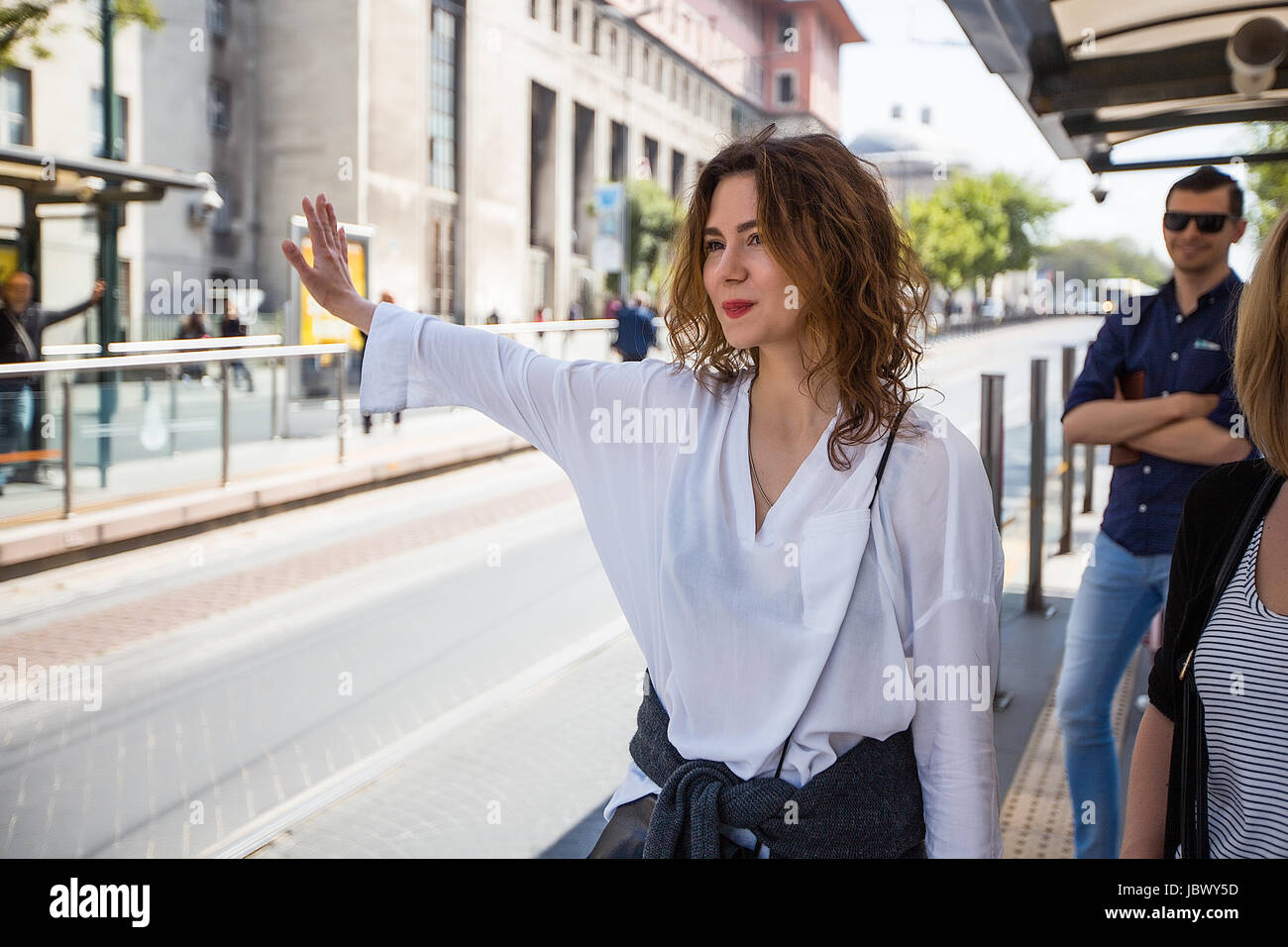 Young woman hailing a bus at city bus stop, Beyazit, Turkey Stock Photo ...