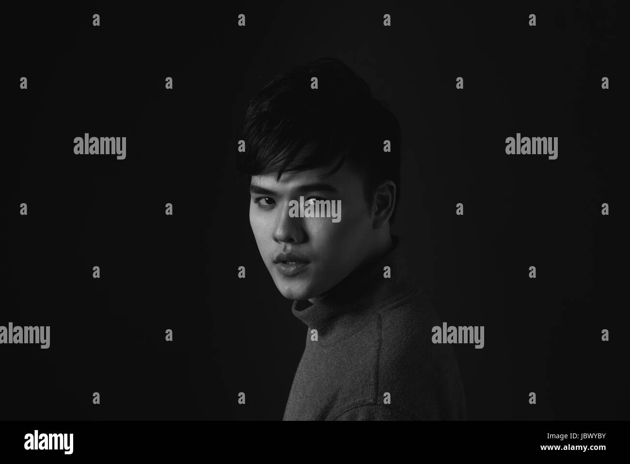 Young asian man's portrait against black background Stock Photo - Alamy