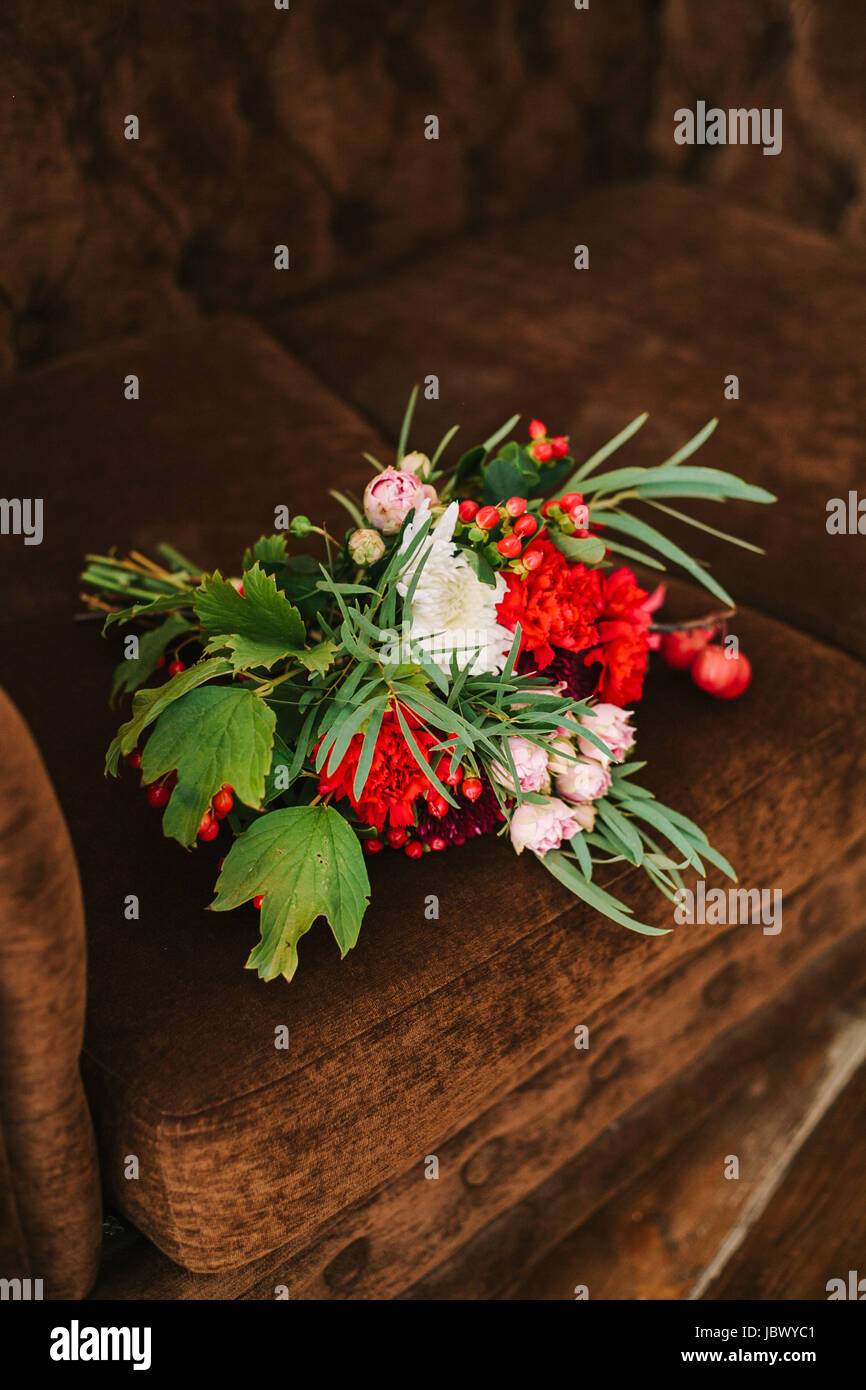 beautiful wedding flowers bouquet from red carnation on a brown velvet ...