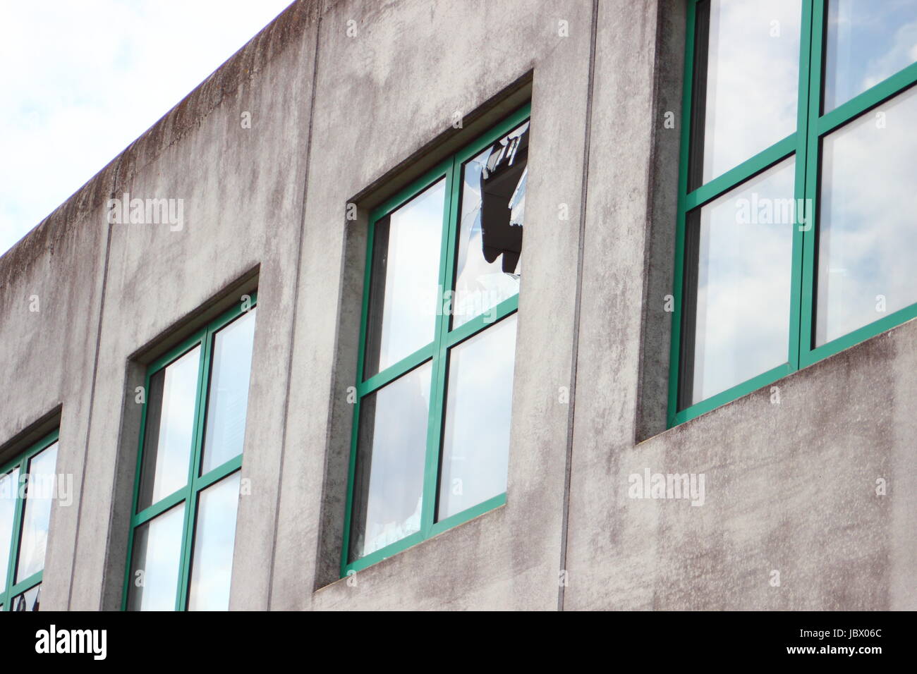Broken glass in window with green frame at factory Stock Photo - Alamy