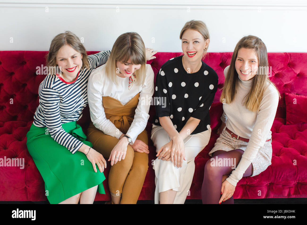 Cheerful women sitting on couch Stock Photo - Alamy