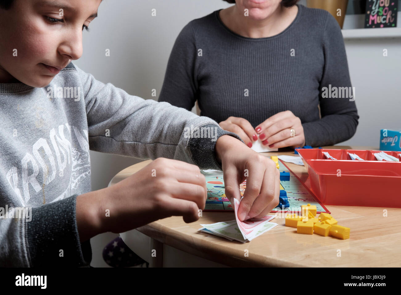 Mother and child playing monopoly board game Stock Photo - Alamy