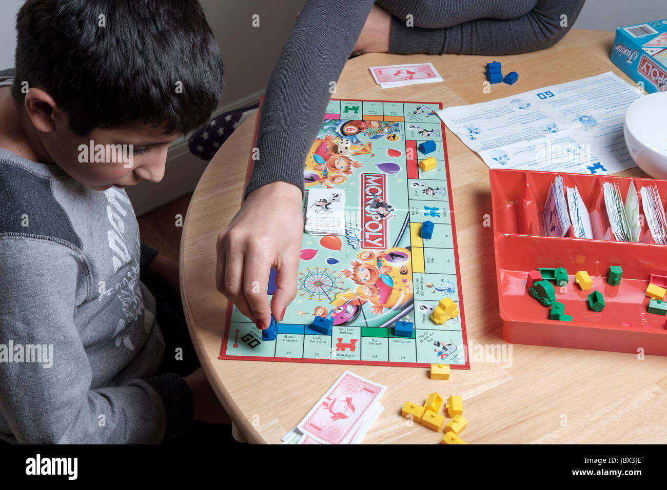 Mother and child playing monopoly board game Stock Photo - Alamy