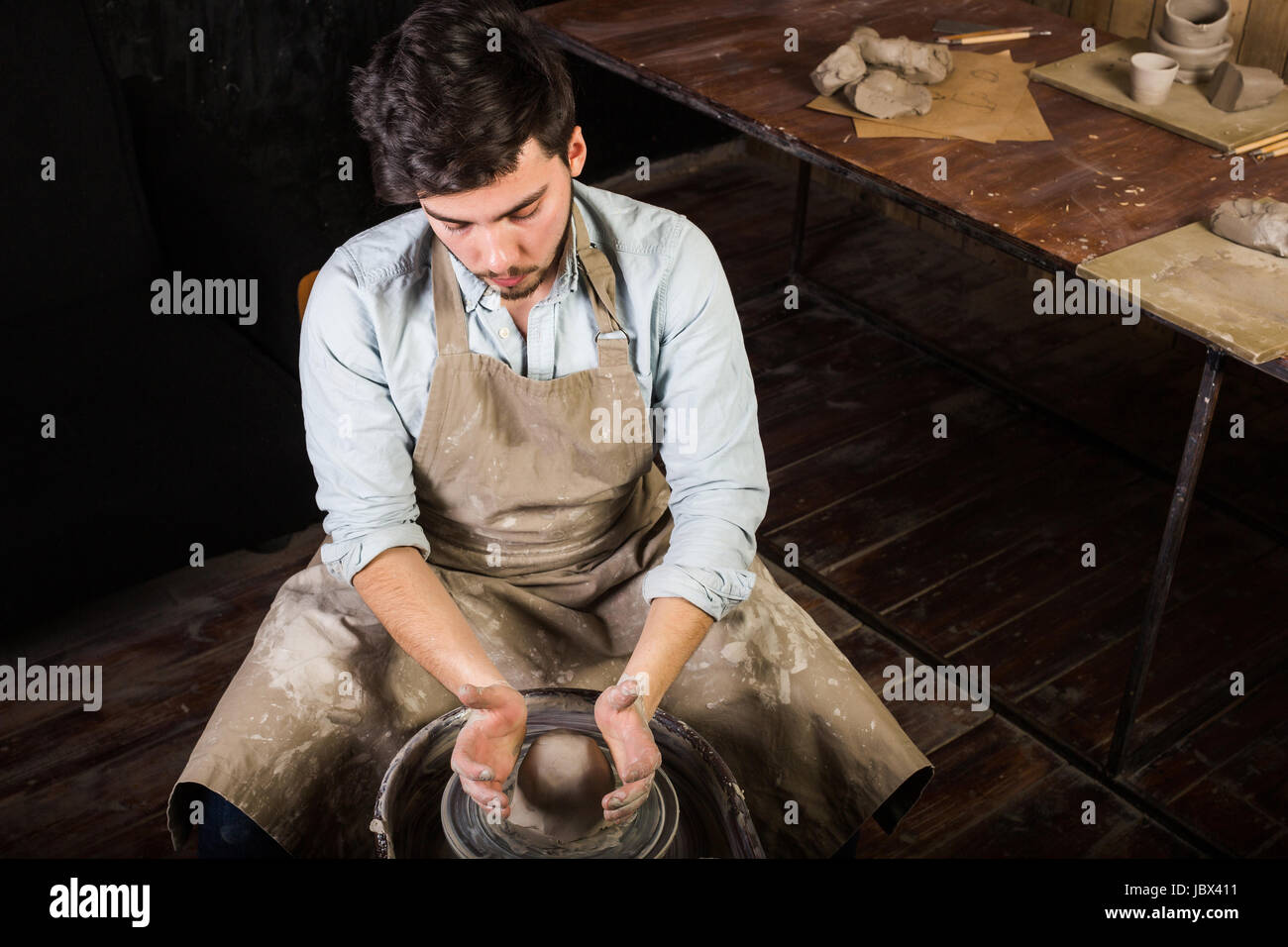 potter, workshop, ceramics art concept - young man working on potter's ...