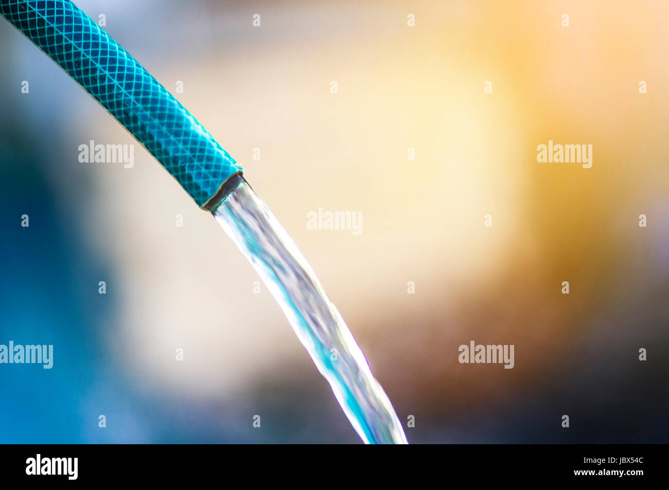 Garden hose with running water, close close Stock Photo - Alamy