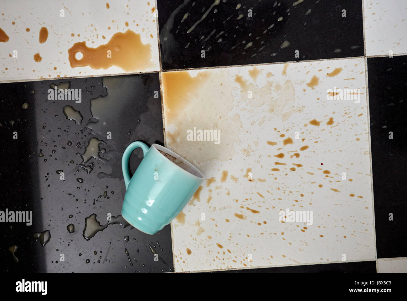 Cup on floor surrounded by spilt coffee, overhead view Stock Photo - Alamy
