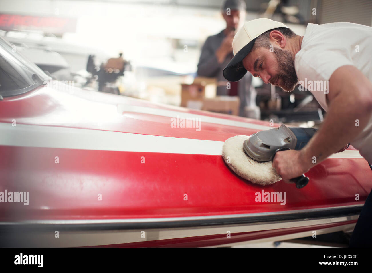 Man polishing boat in repair workshop Stock Photo - Alamy