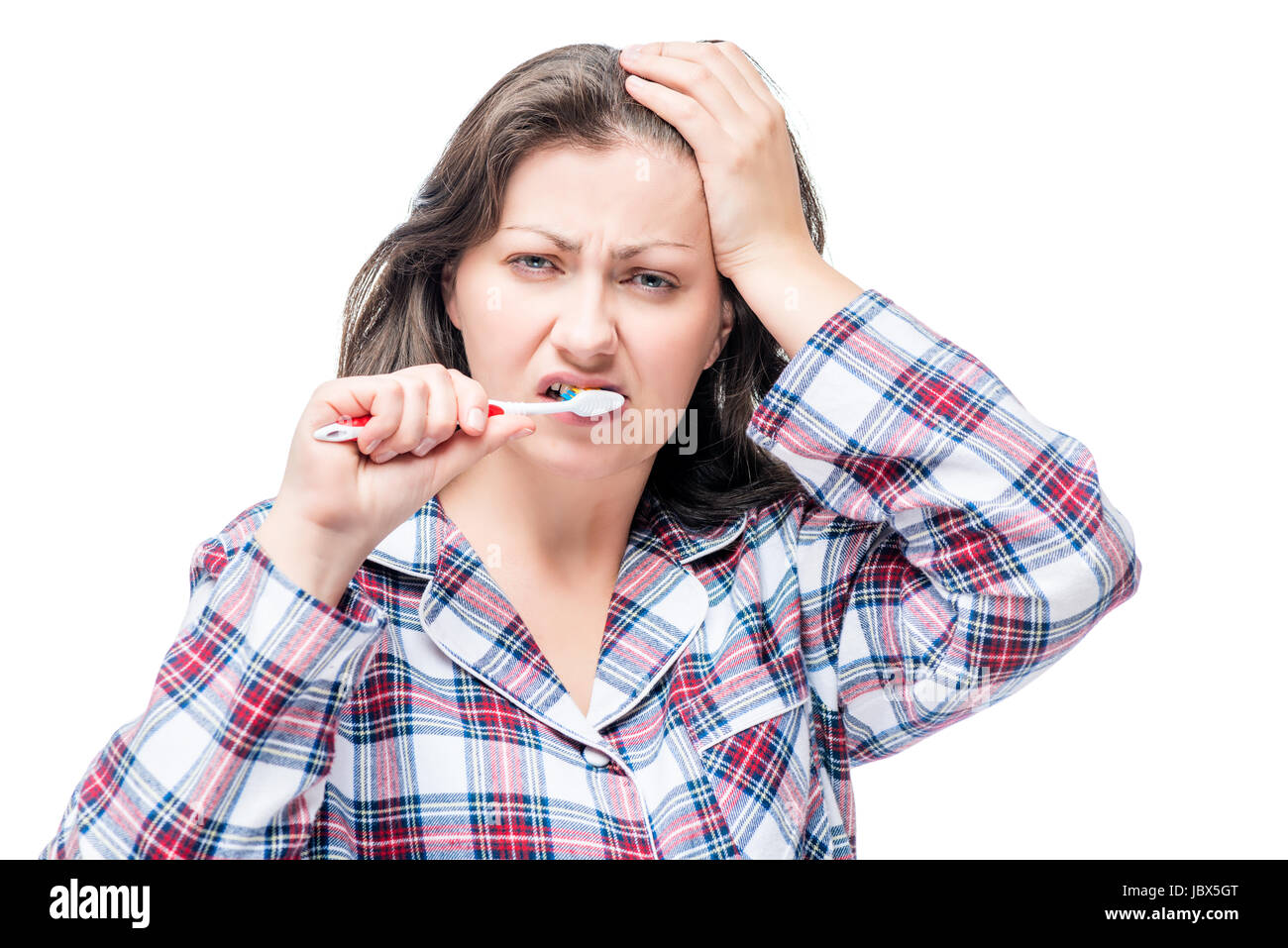 Sleepy dissatisfied woman brushing her teeth after waking, isolated ...