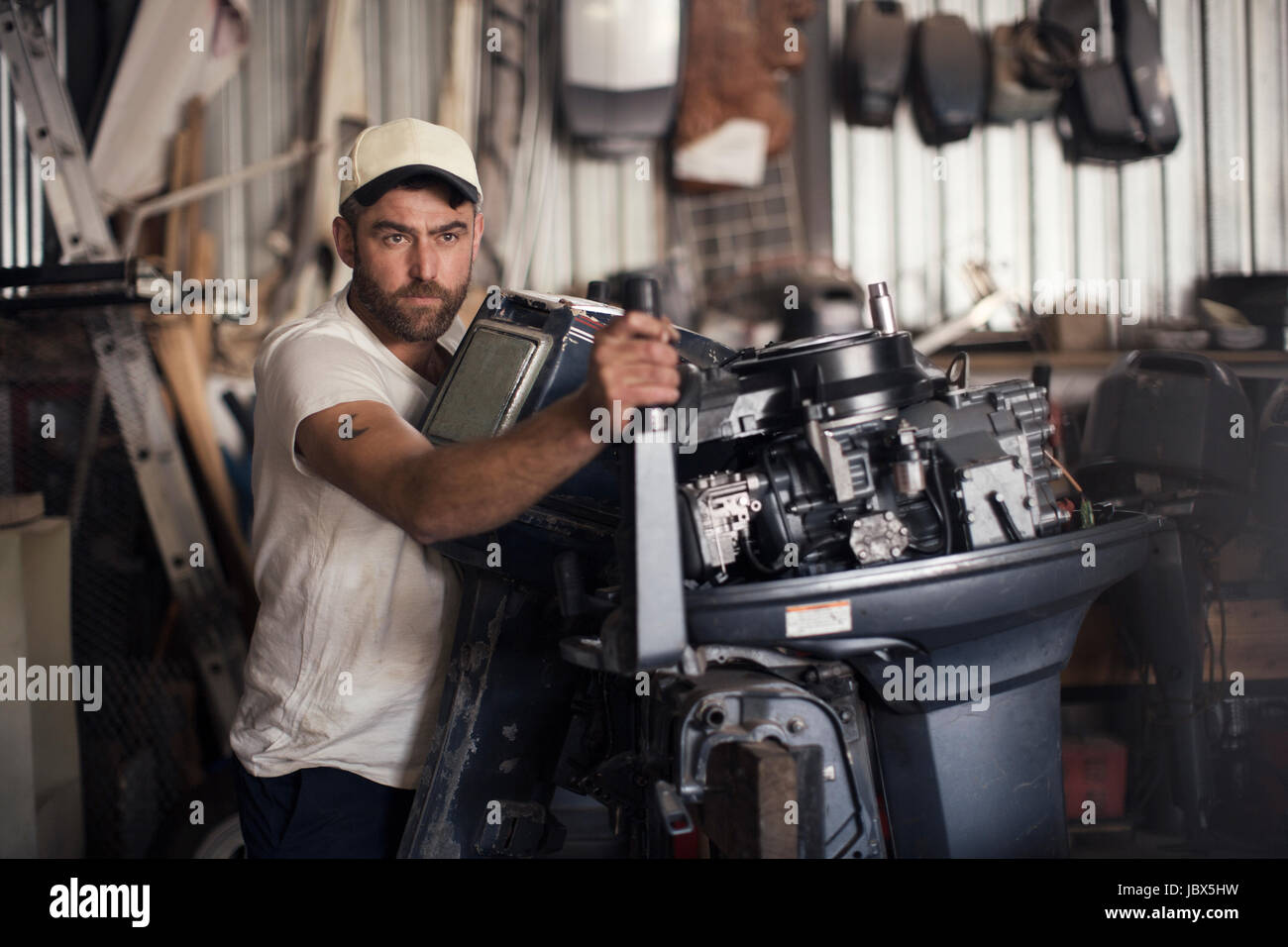 Man testing outboard motor in boat repair workshop Stock Photo - Alamy