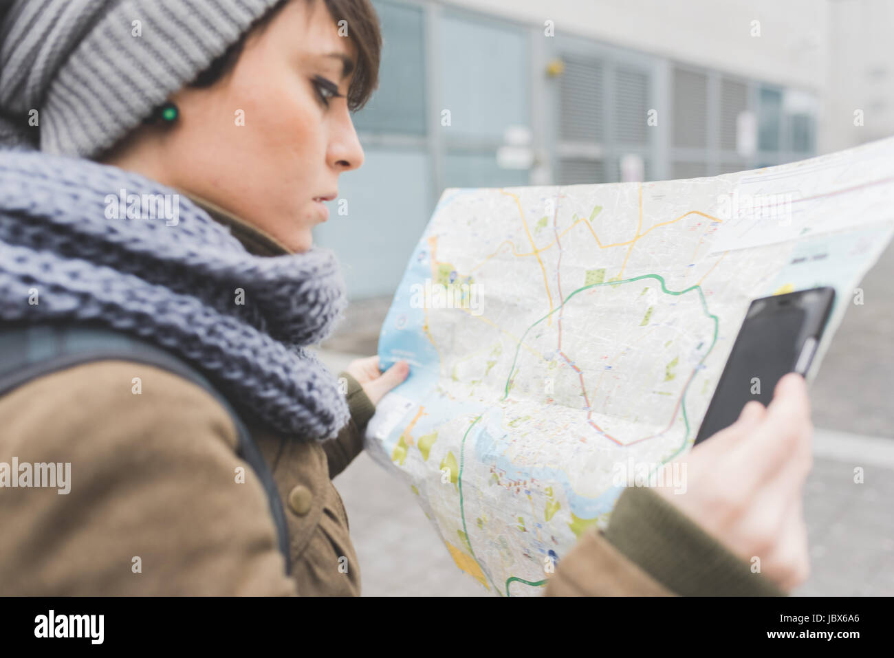 Female backpacker with smartphone looking at map in city Stock Photo ...