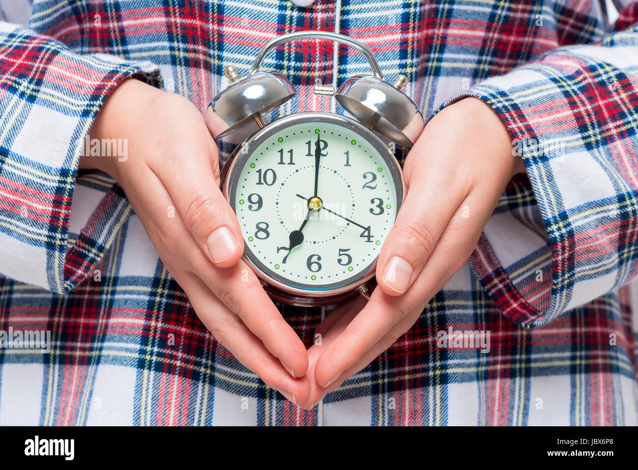 7 am shows alarm clock in female hands Stock Photo - Alamy
