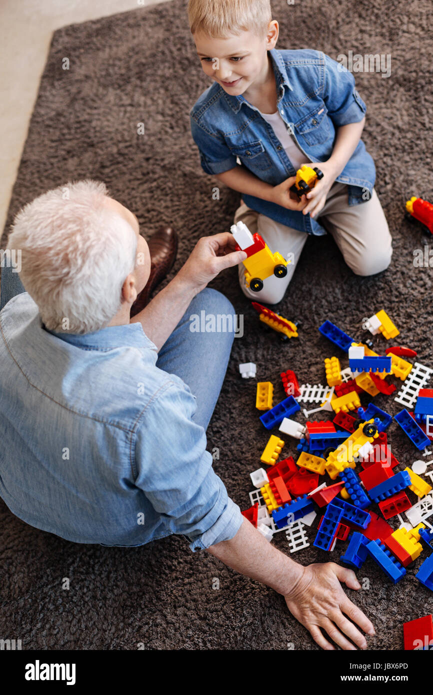 Active inspired grandpa joining his grandson in game Stock Photo - Alamy
