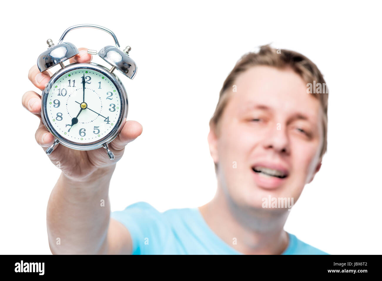 Close-up of an alarm clock in a male hand on a white background in ...