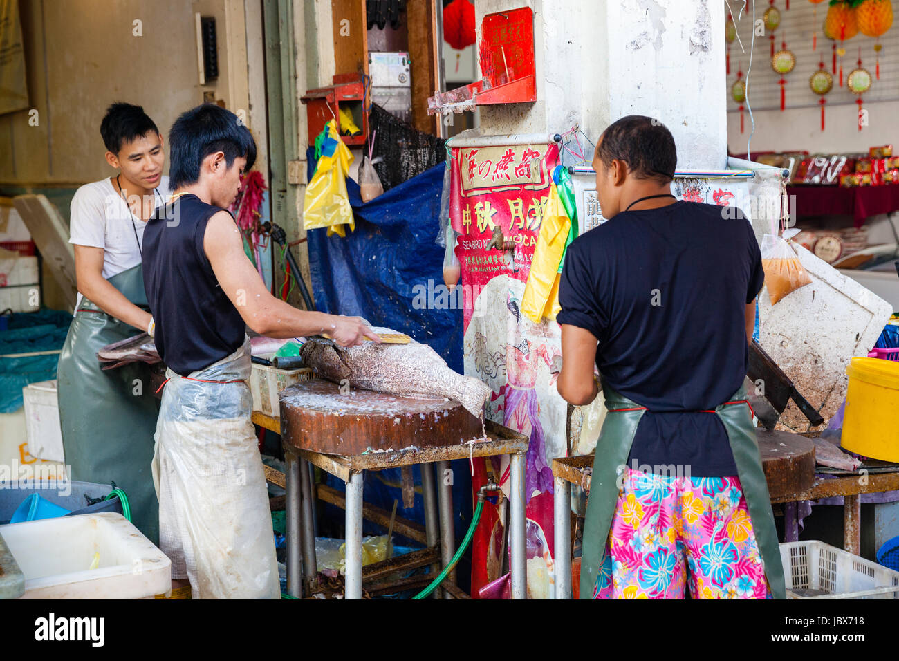 GEORGE TOWN, MALAYSIA - MARCH 23: Fishmonger cleans fresh fish for ...