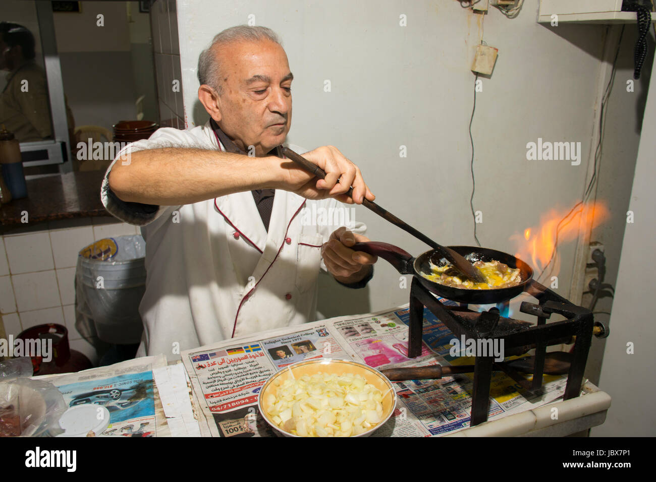 Chef working in a restaurant kitchen , frying eggs and lamb Beirut ...