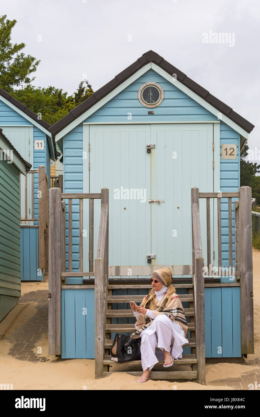 Woman sat on steps of beach hut hi-res stock photography and images - Alamy