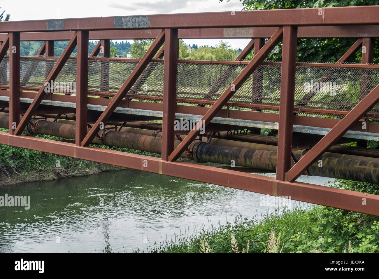 A rusted metal bridge spans the Green River in Kent, Washington Stock ...