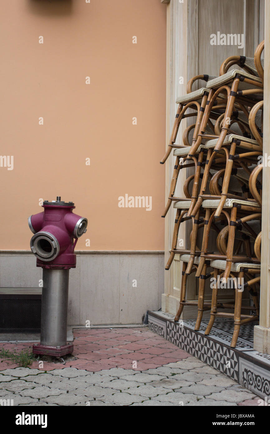 fire hydrant near closed cafe restaurant with stocked chairs waiting ...