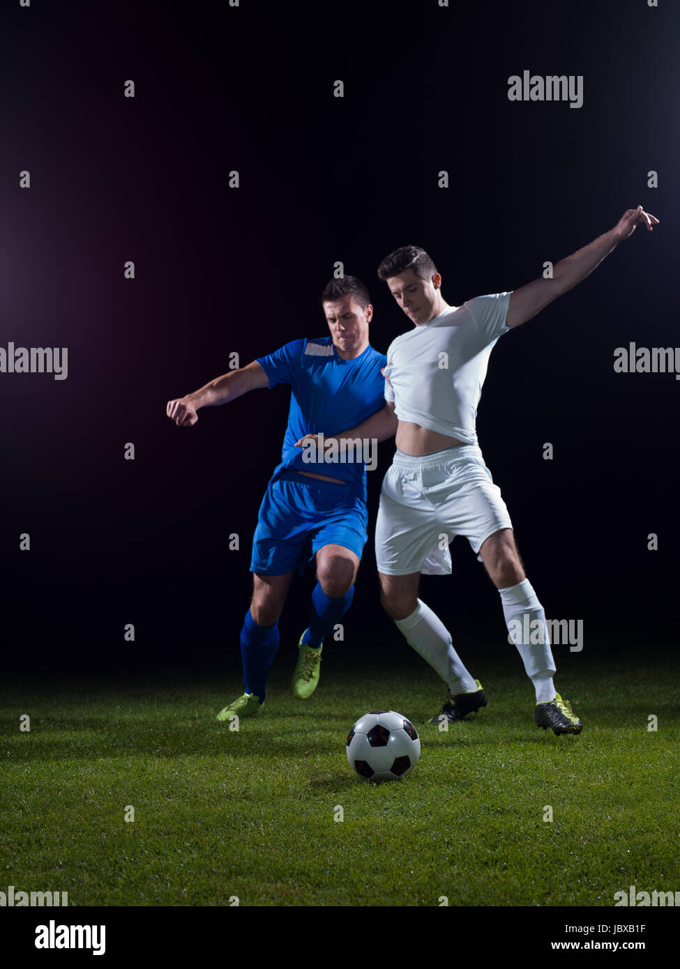 soccer player doing kick with ball on football stadium field isolated ...