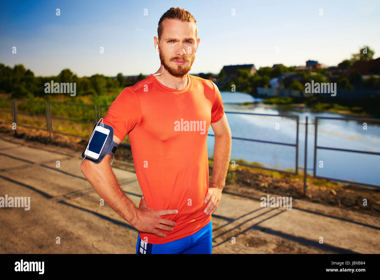 Portrait of young attractive sportsman looking at camera outside Stock ...