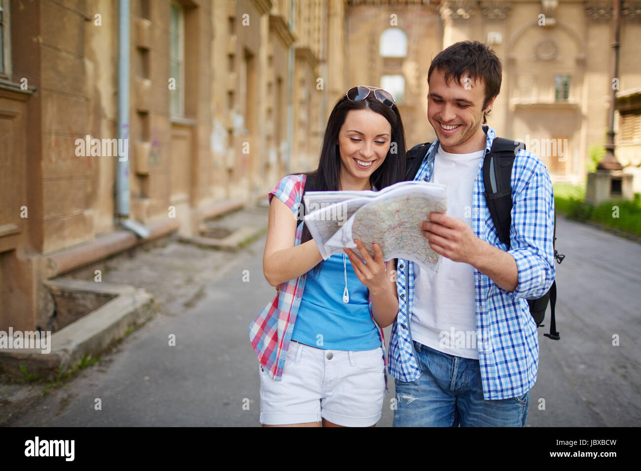Couple of travelers looking at map of the town that they visiting Stock ...
