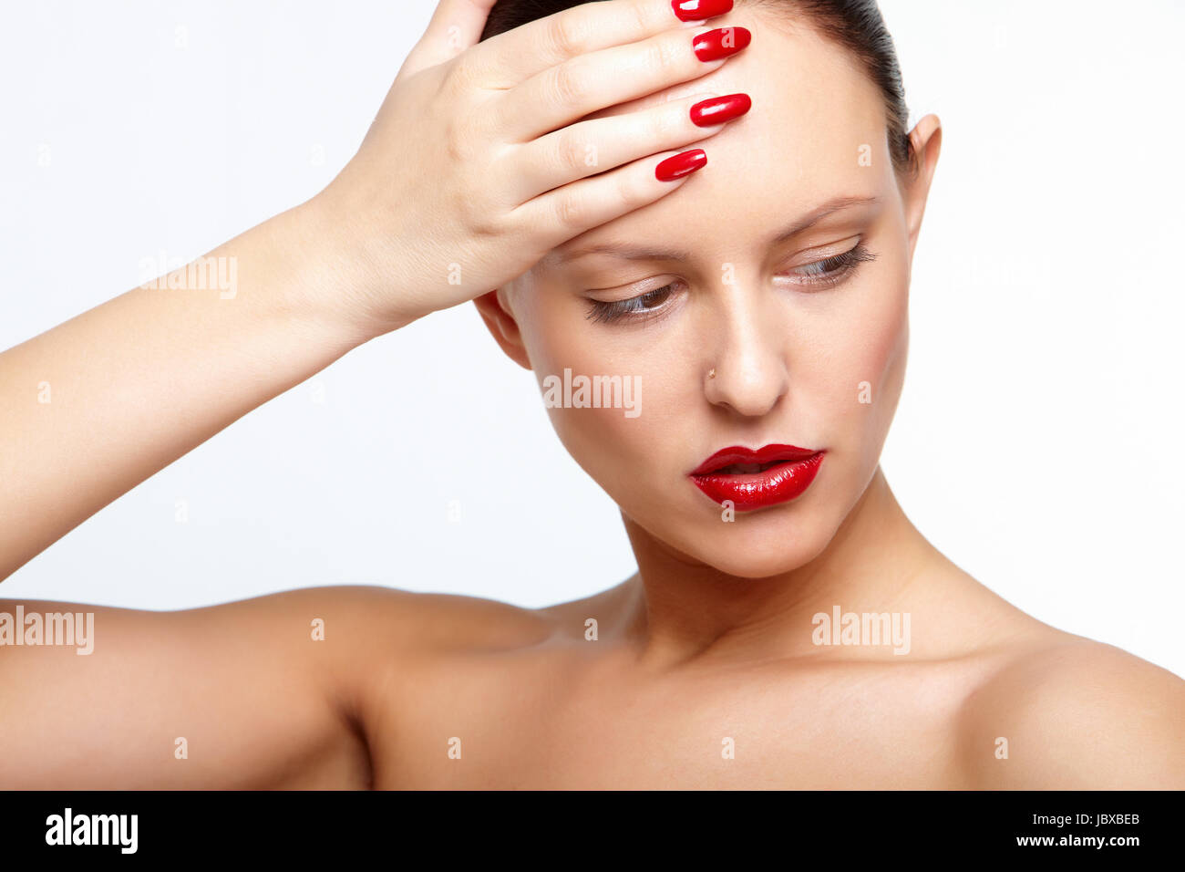 Posh woman with red lips and fingernails touching her forehead Stock ...