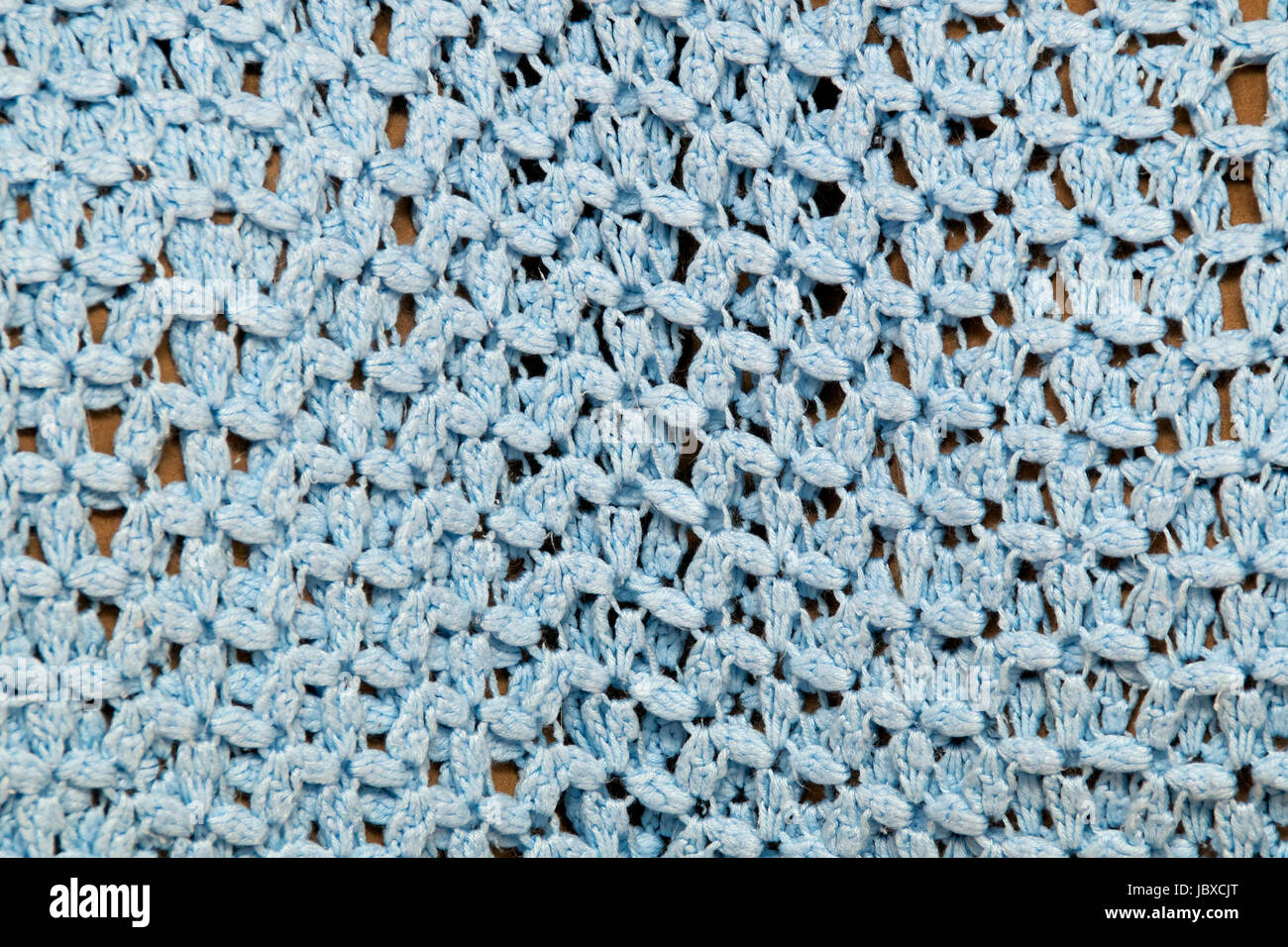 A large blue crocheted afghan blanket fills the frame of this image ...