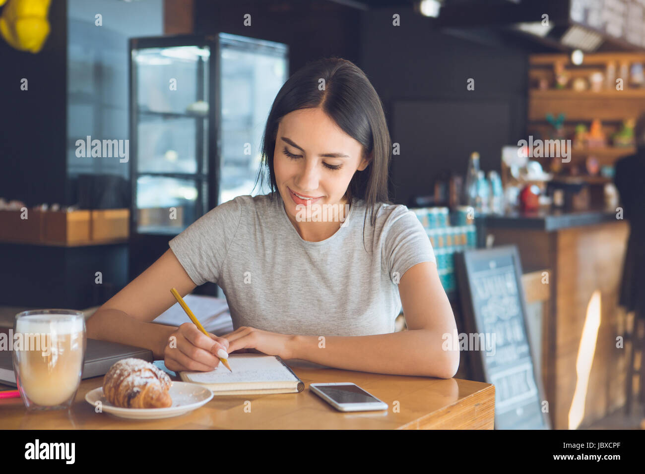 Young female sitting in a cafe indoors rest writing planner Stock Photo ...