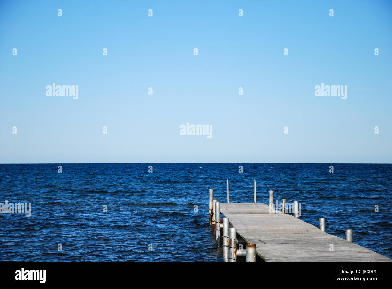 Wooden bath pier at blue water by the coast of the swedish island Oland ...