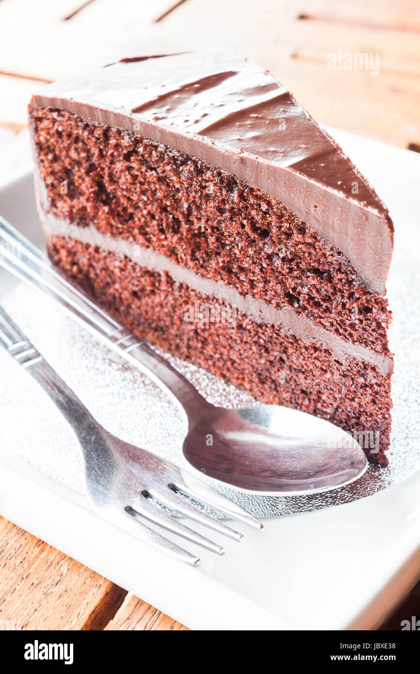 Piece of chocolate cake serving with spoon and fork Stock Photo - Alamy