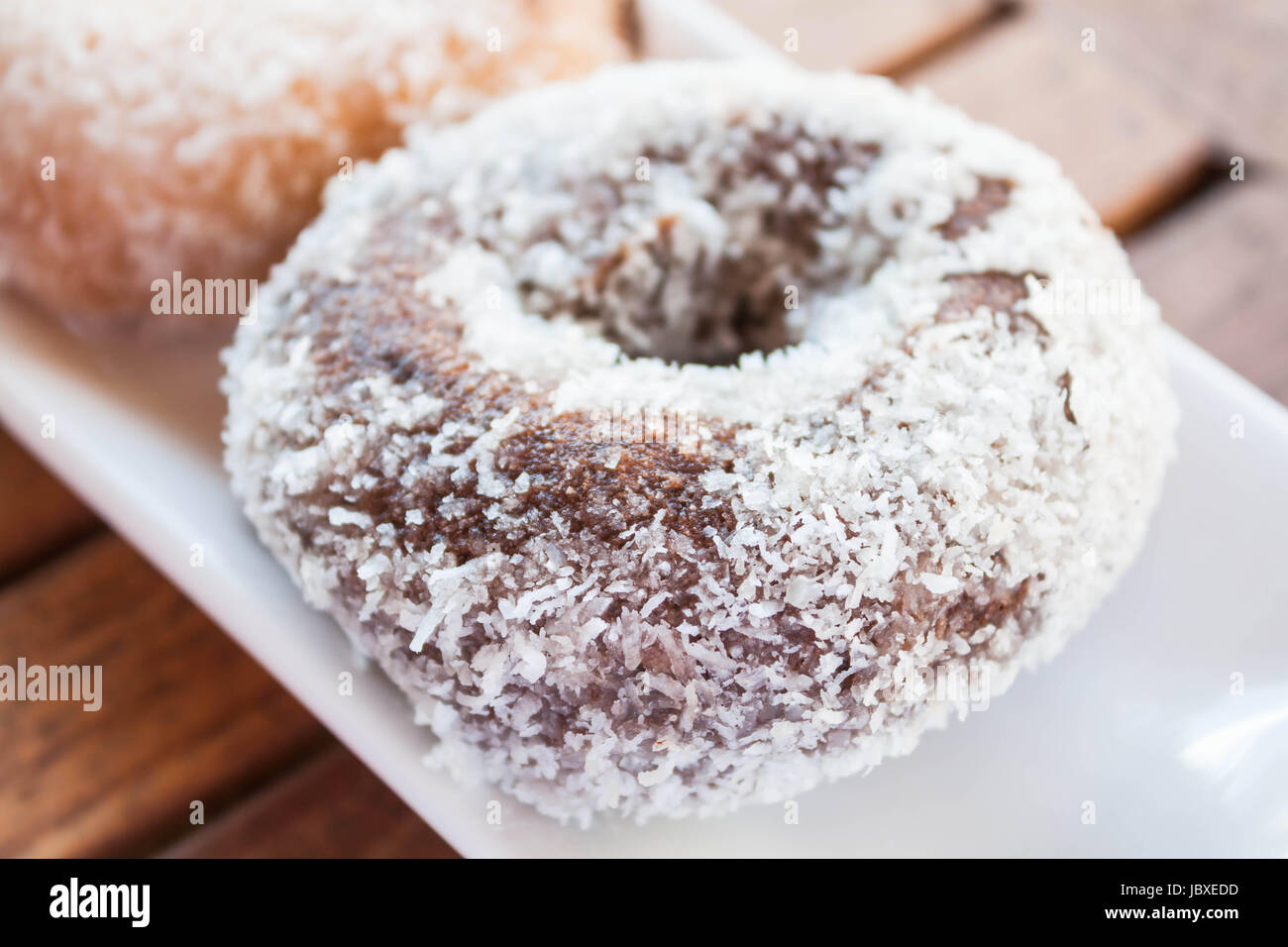 Close up chocolate coconut donut on white plate, stock photo Stock ...