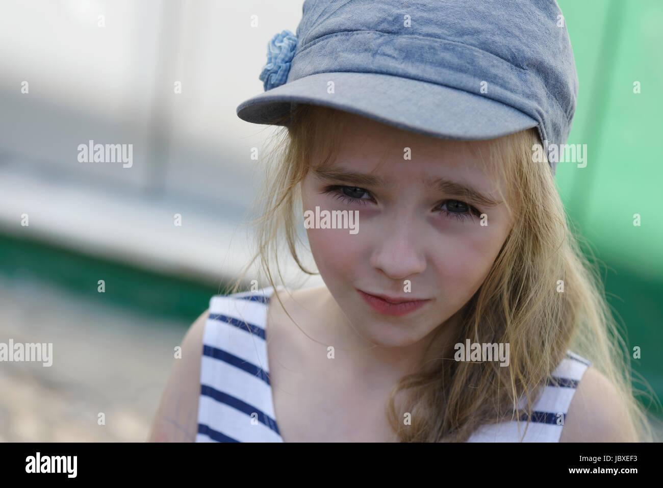 Portrait of cute girl in denim cap looking up seriously Stock Photo - Alamy