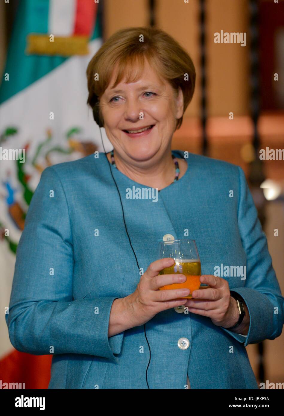 German Chancellor Angela Merkel smiles as she holds a beer following a ...