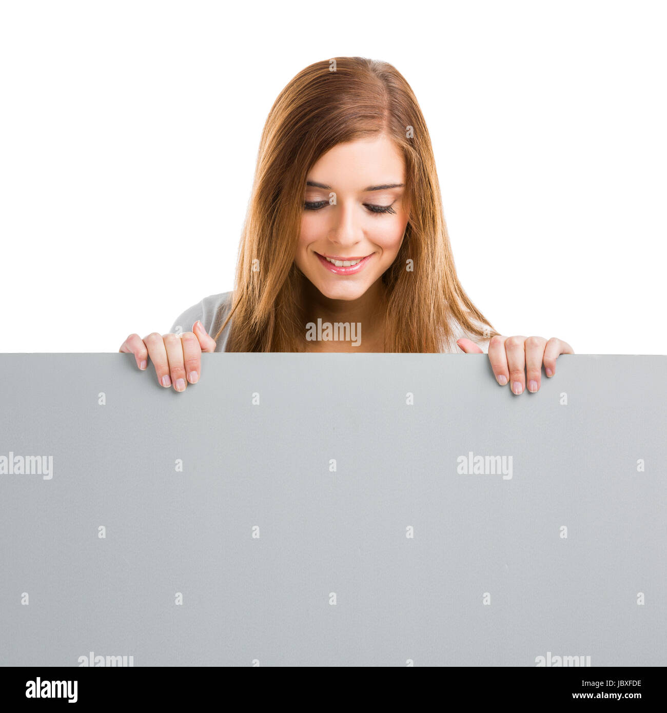 Young and beautiful woman holding and looking to a big blank board ...