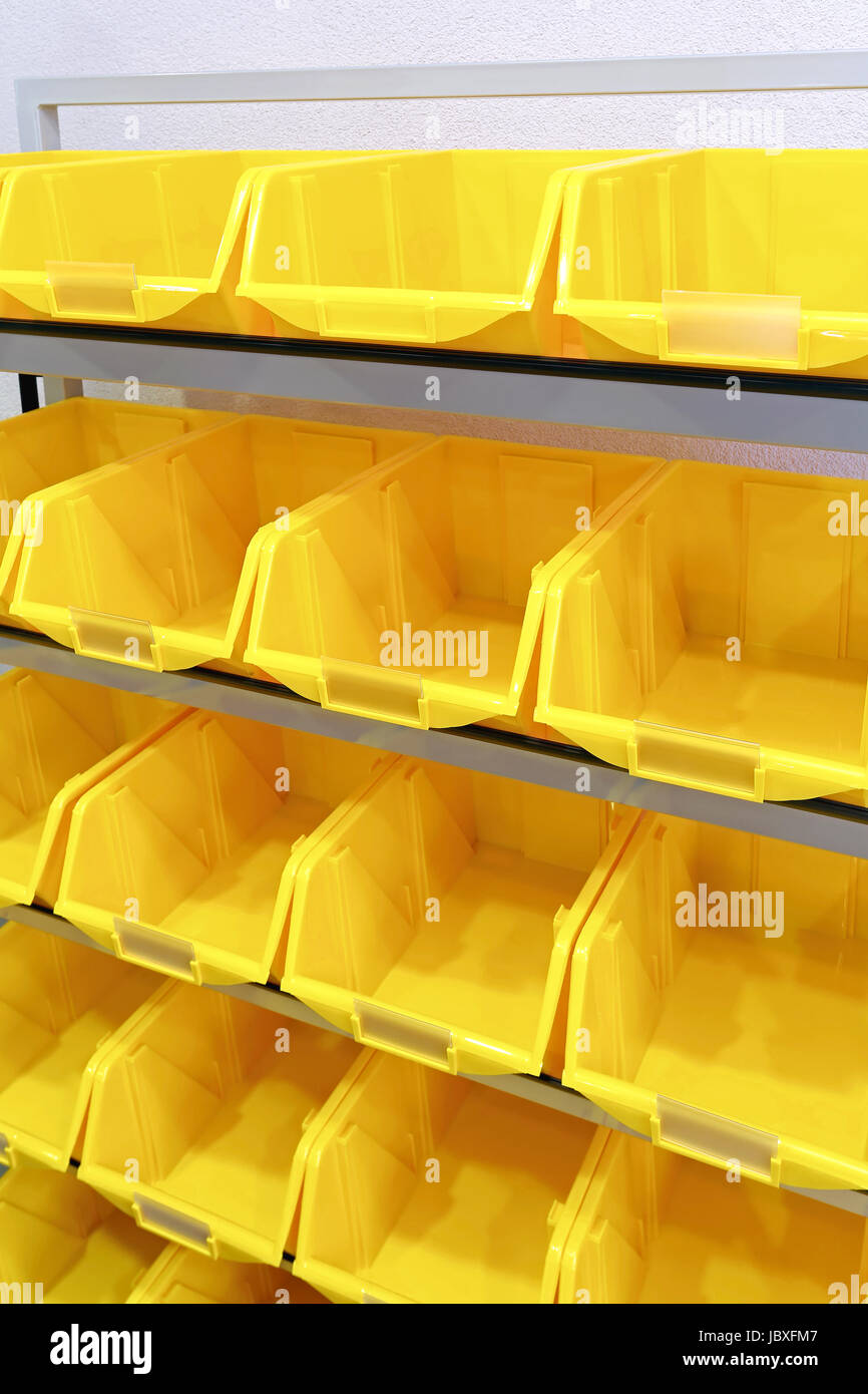 Yellow plastic racks for parts at wall Stock Photo - Alamy